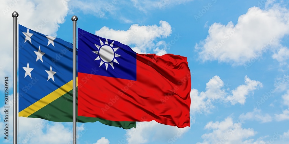 Solomon Islands and Taiwan flag waving in the wind against white cloudy ...