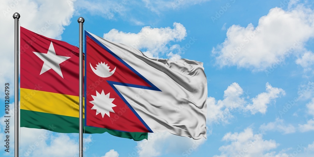 Togo and Nepal flag waving in the wind against white cloudy blue sky ...