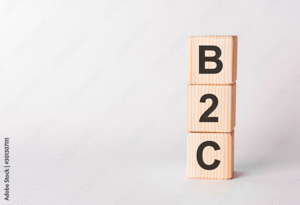 B2C letters of wooden blocks in pillar form on white background, copy ...