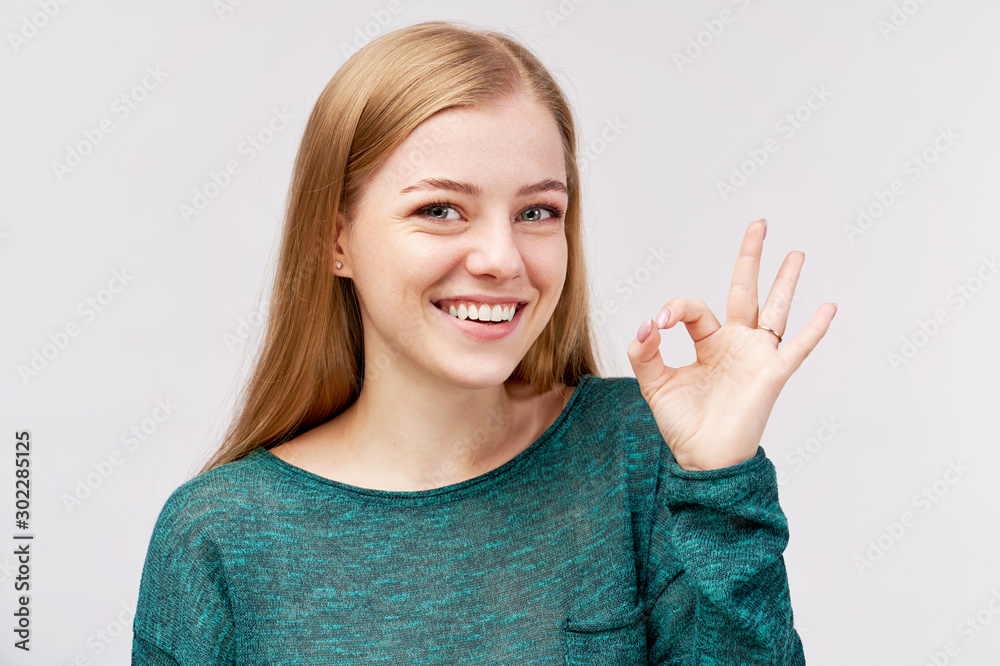 ภาพถ่าย Stock Pleased young woman shows good job or well done, makes ...