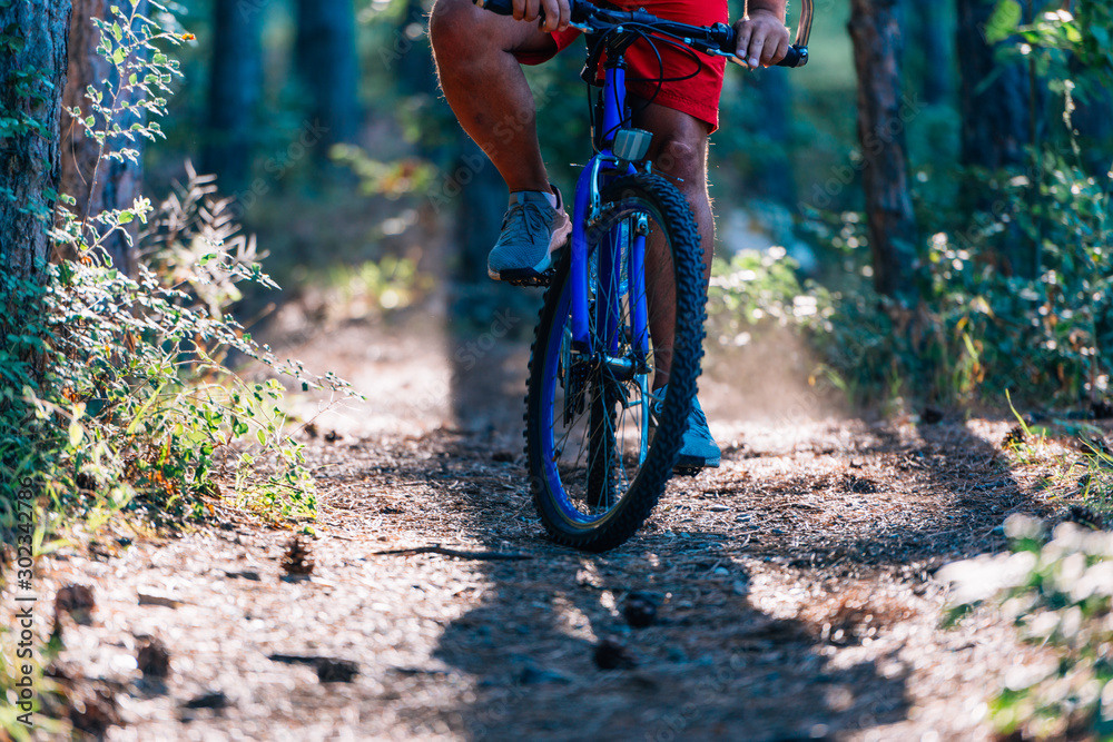 Older overweight man rides a mountain bike through the woods using ...