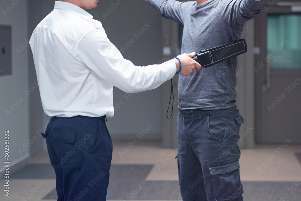Security guard making a pat-down procedure for finding hidden objects ...