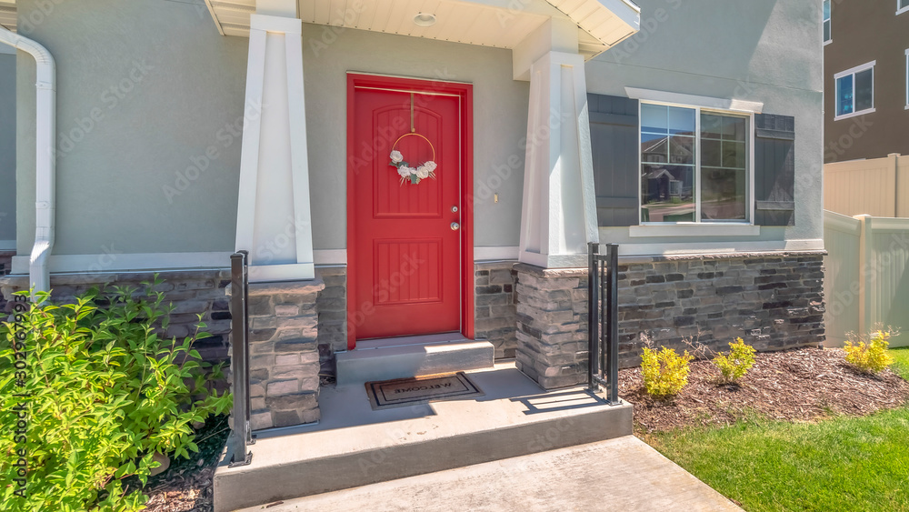Panorama frame Piched roof over the vivid red front door with pillars ...