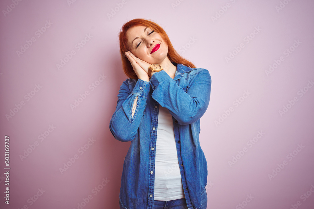 Youg beautiful redhead woman wearing denim shirt standing over isolated ...