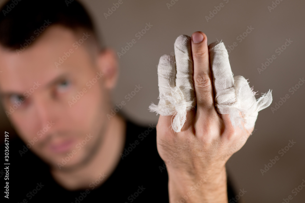 guy shows bandaged fingers. Only the middle finger is not bandaged ...