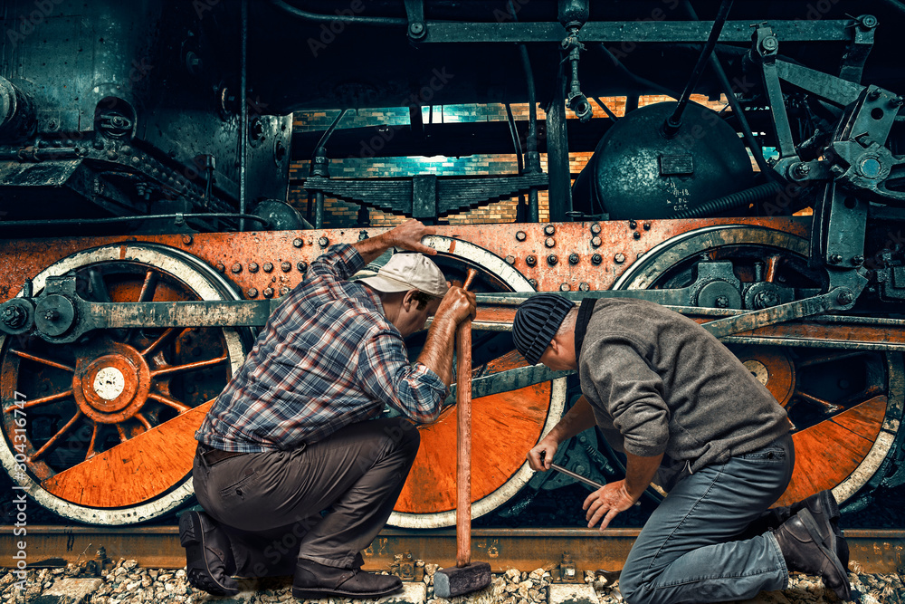 Two mechanics repair an old steam locomotive in a depot Stock Photo ...