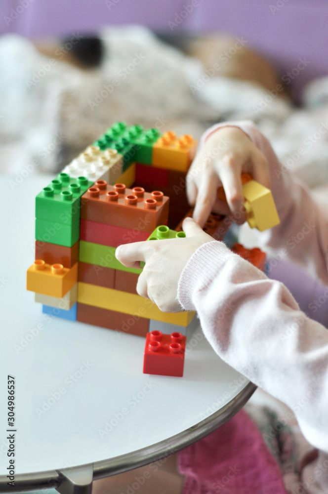 Child playing with plastic colorful blocks constructor. Close up of ...