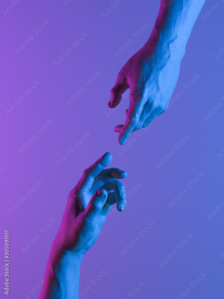 human hands in neon light Stretched towards each other as a symbol of ...