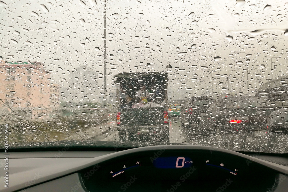 Stock-Foto „Road view through front car window mirror with rain drops ...