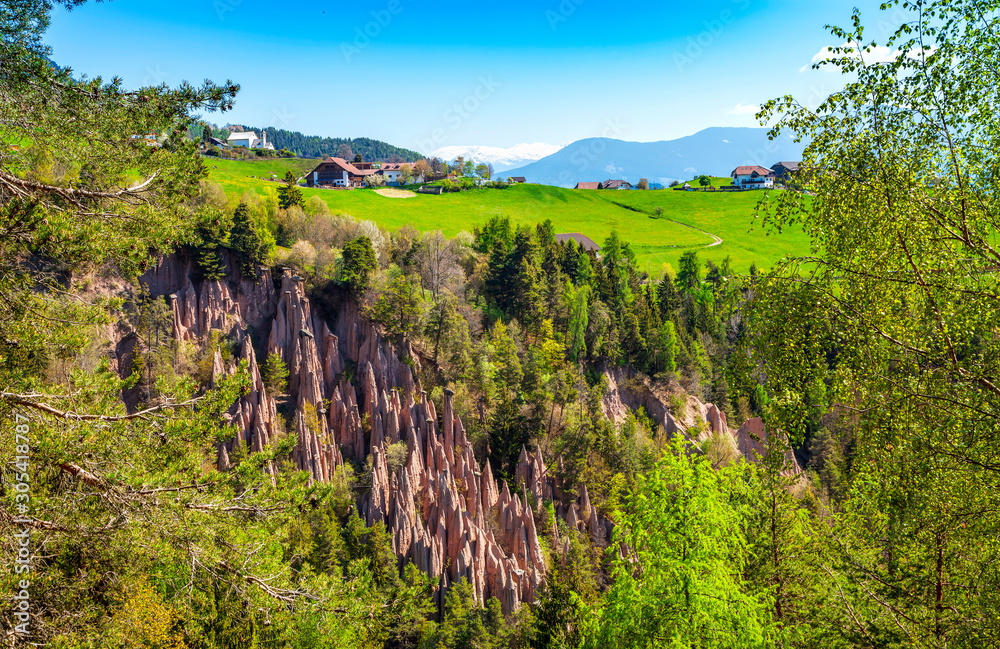 Earth pyramids of Ritten (Renon) and small village in the Dolomites ...