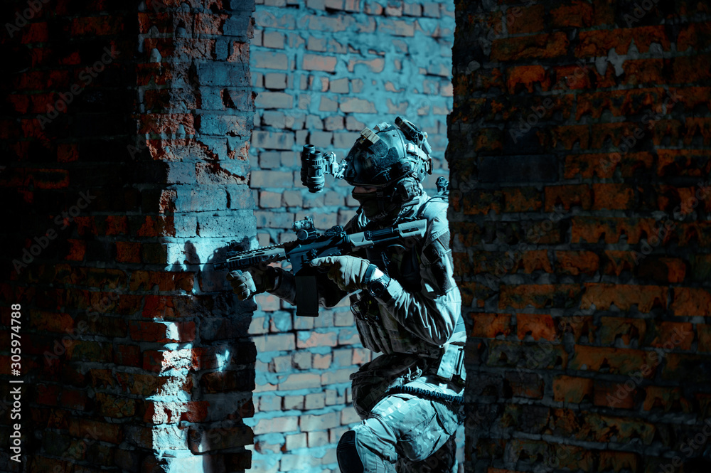 Man in uniform with machine gun and night-vision device move between ...