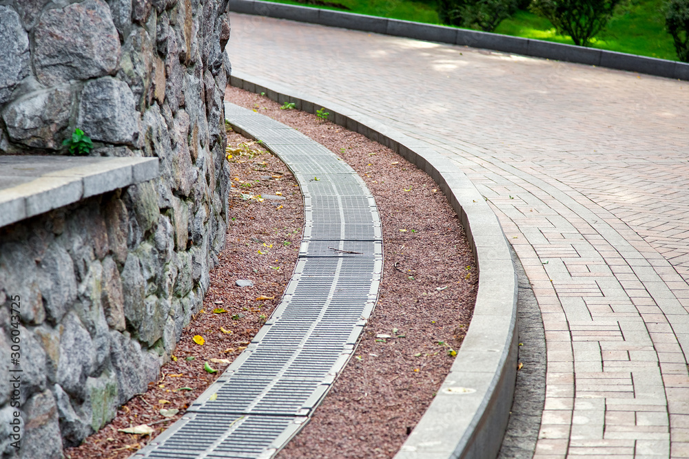 grille of the drainage system on the curve pedestrian sidewalk of turn ...
