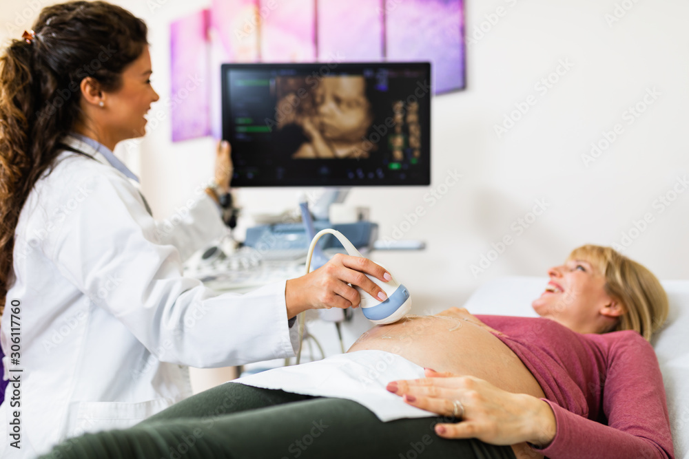 Beautiful and happy expectant mother doing ultrasound scan in the ...