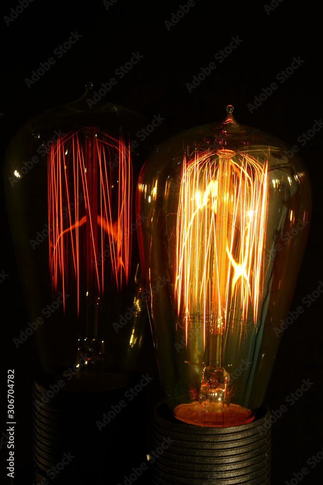 Clear glass electric lightbulb dimmed to enable it's tungsten filament ...