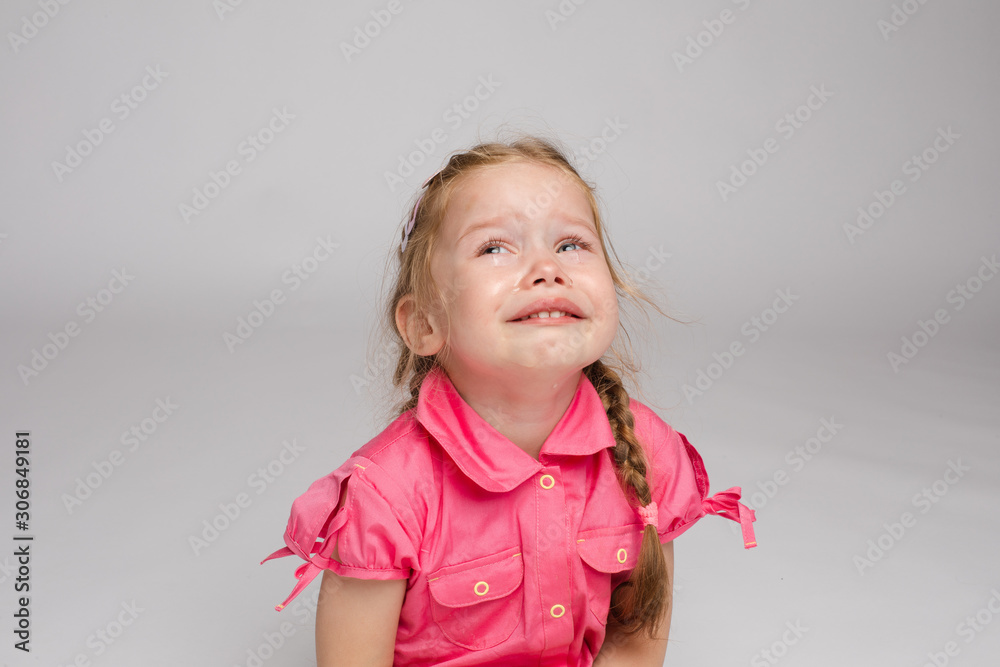 Stock photo of sweet little girl with braids in pink dress crying while ...