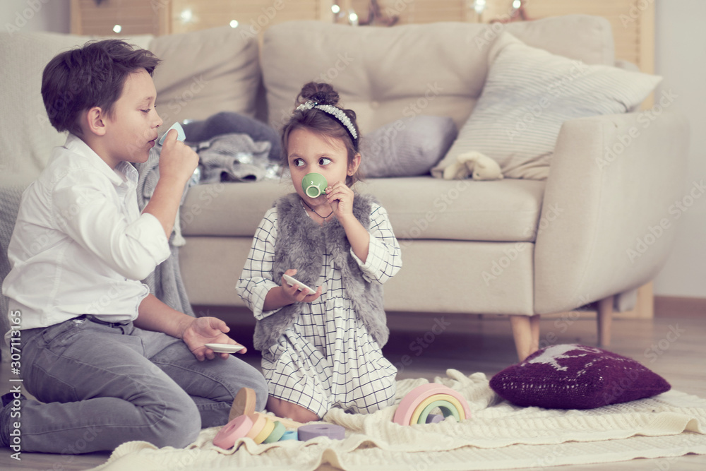 brother and sister are playing on the floor at home. little girl ...