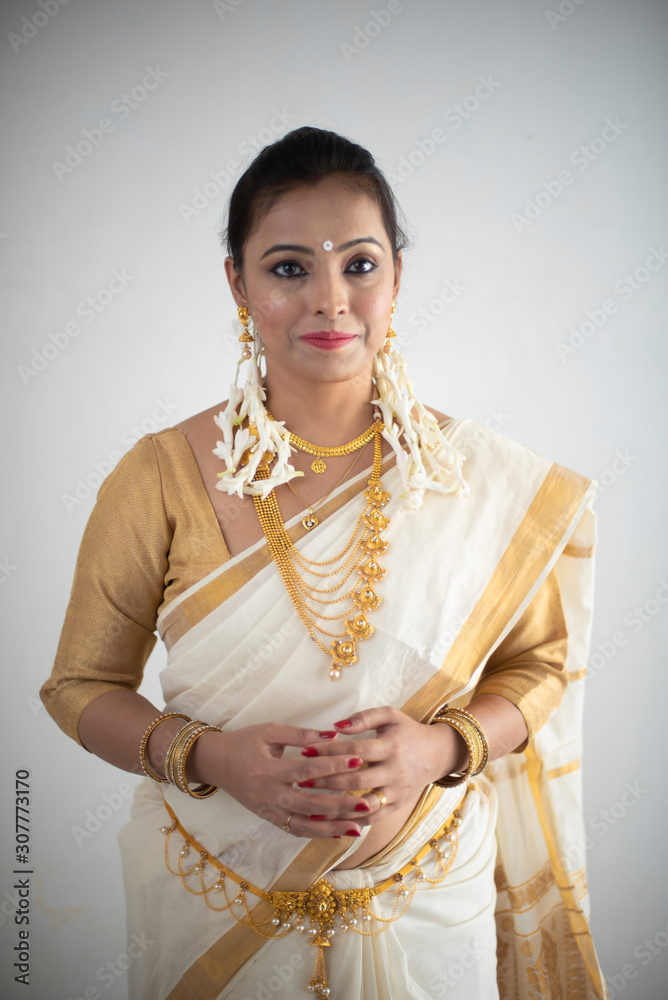 Portrait of an young and attractive Indian woman in white traditional ...