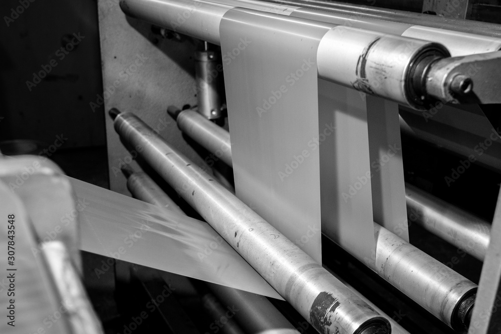 Foto Black & White imagery of spool of plastic packaging sheet heavy ...