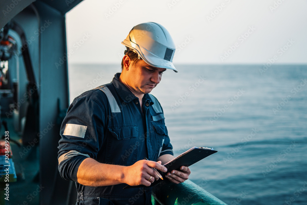 Deck Officer on deck of offshore vessel or ship , wearing PPE personal ...