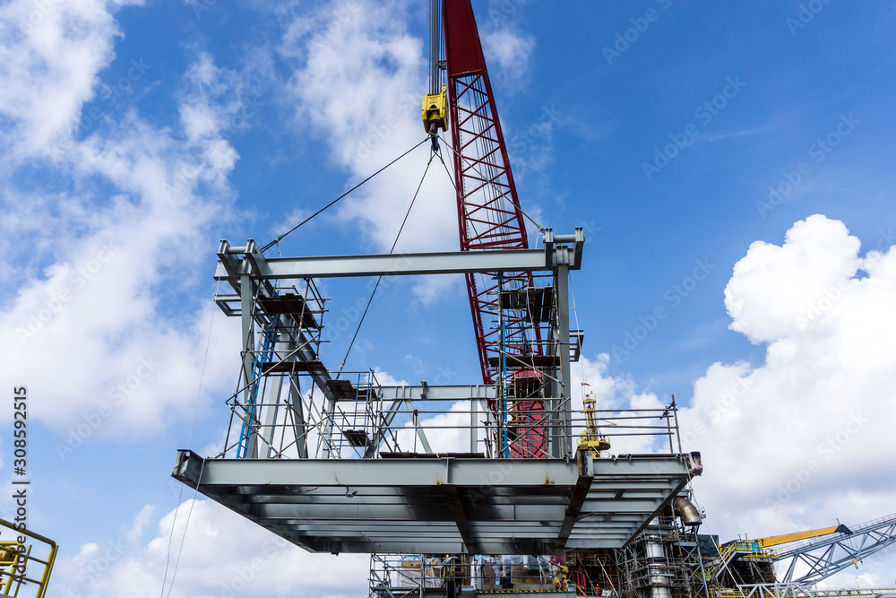 Offshore crane on board a construction work barge performing heavy ...