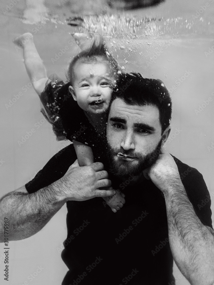 handsome cheerful father teaching his little daughter to dive ...