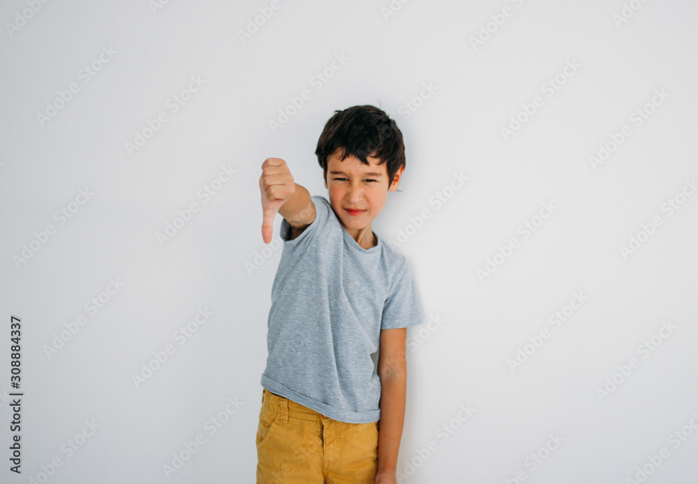 Frustrated Moody tween boy shows negative gesture on white background ...
