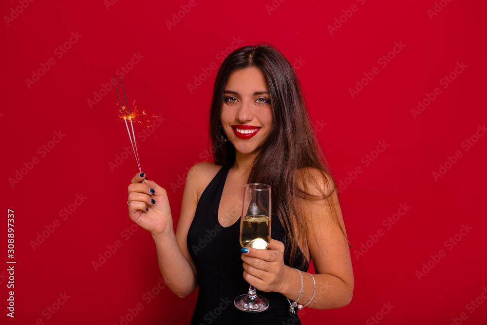 gorgeous woman with dark long hair wearing black dress with bare shoulders holding a glass of ...