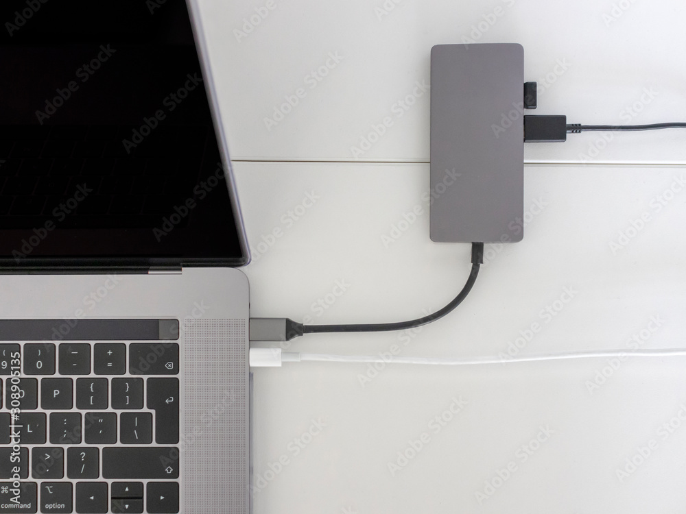 Laptop with usb-c hub on white desk Stock Photo | Adobe Stock