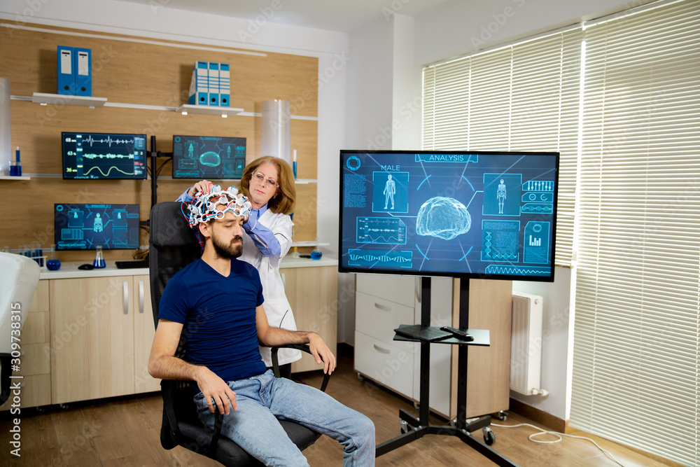 Doctor installing scanning device on the head of a male patient. Stock ...
