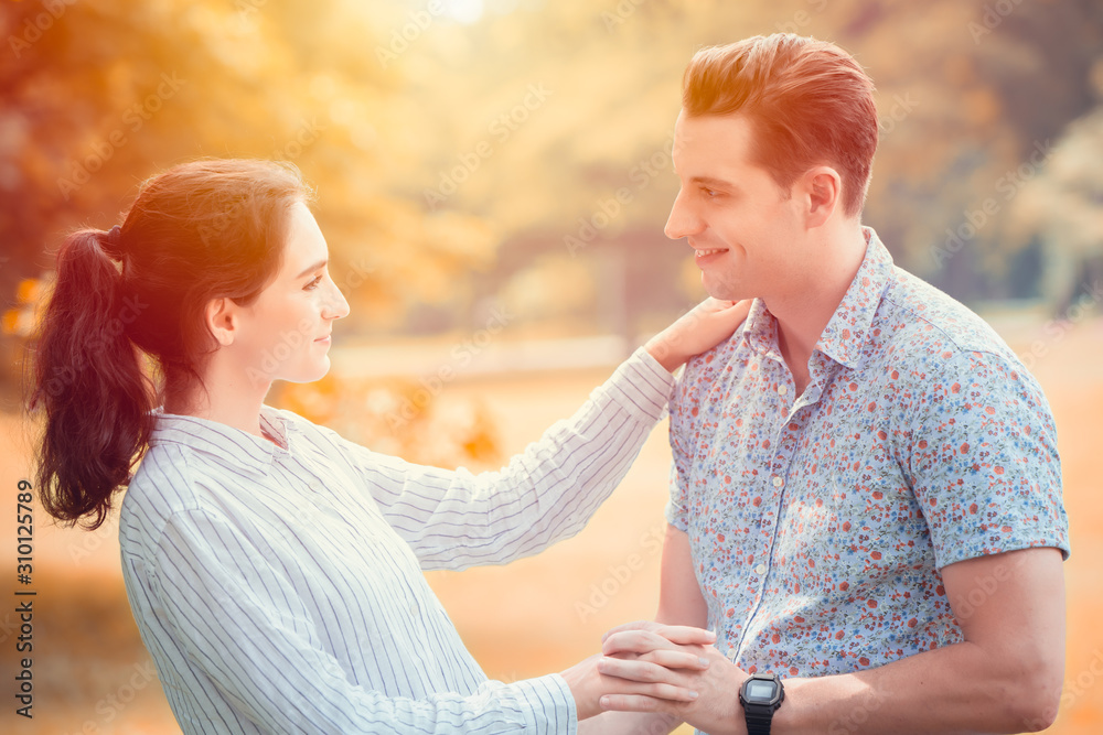 Couple of lovers holding hands together smiling in the garden ...