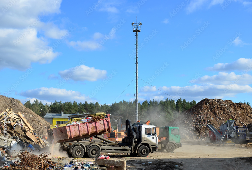 Fotografie Garbage truck unloads construction waste from container at ...