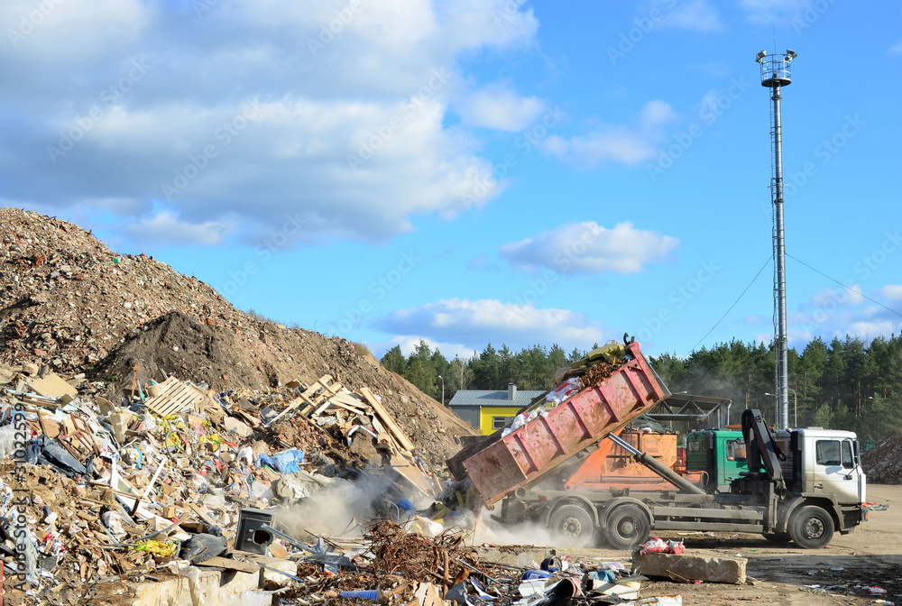 Garbage truck unloads construction waste from container at the landfill ...