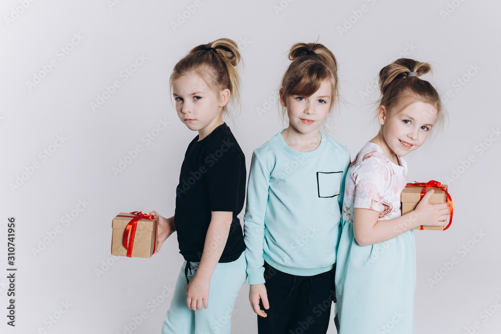 Happy cute adorable blondie triplets girls posing in studio together ...