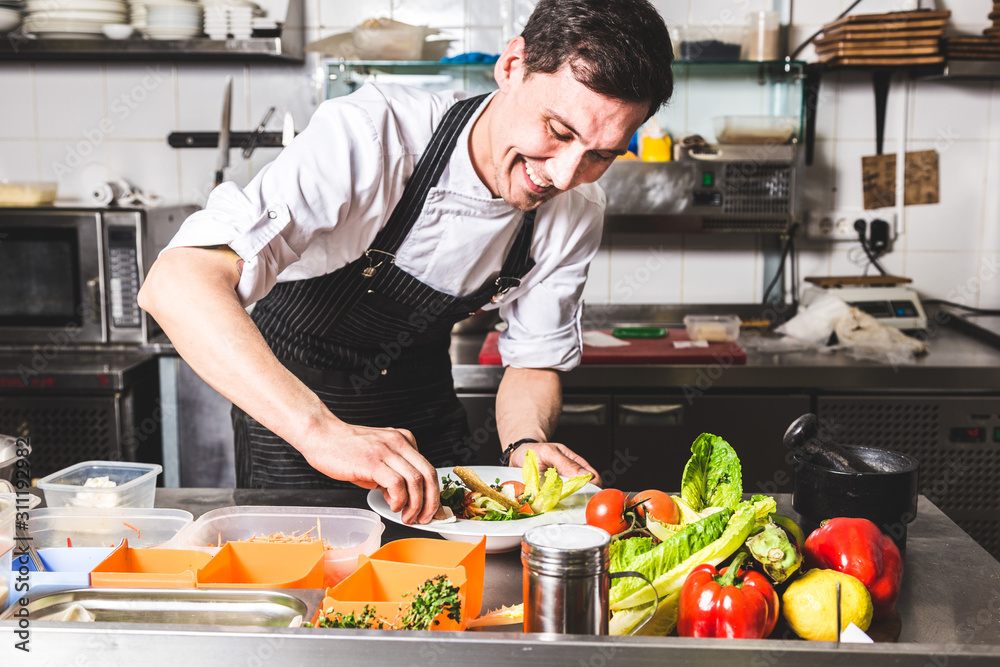 Professional chef cooking in the kitchen restaurant at the hotel ...