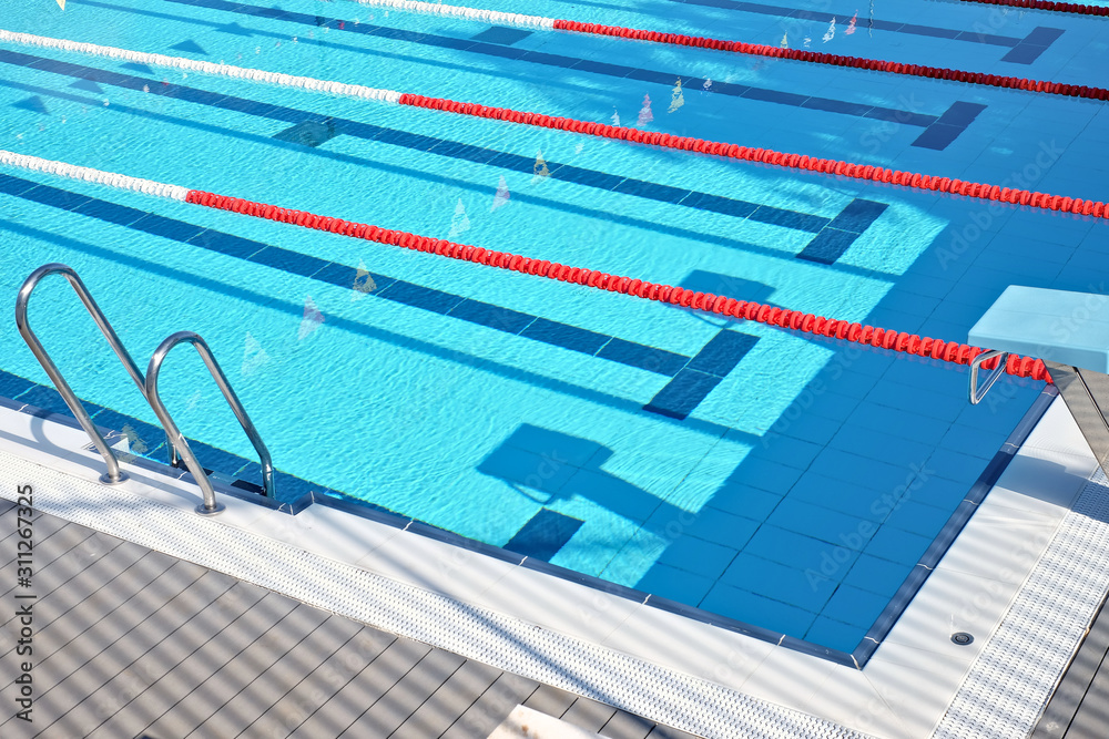A blue swimming pool with starting platforms, swimming lanes markings ...