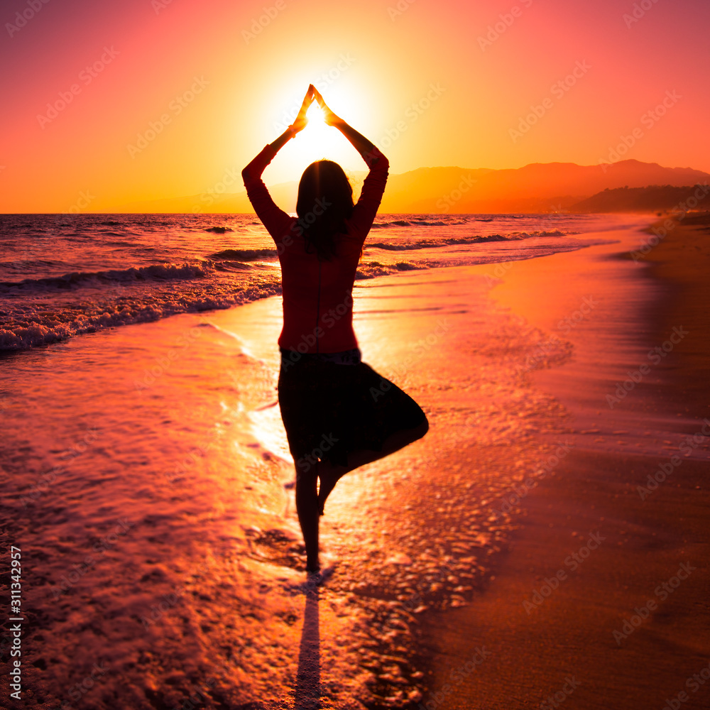 Girl silhouette in yoga Vrksasana Tree Pose balancing on one leg in ...