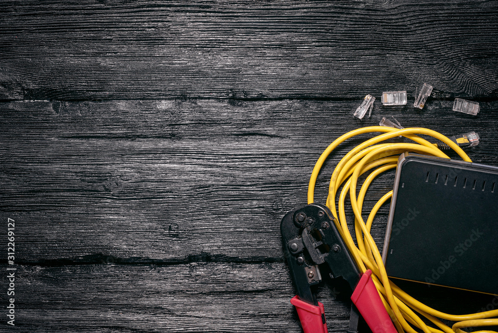Computer network laying concept. Crimper tool, utp cable, net switch ...