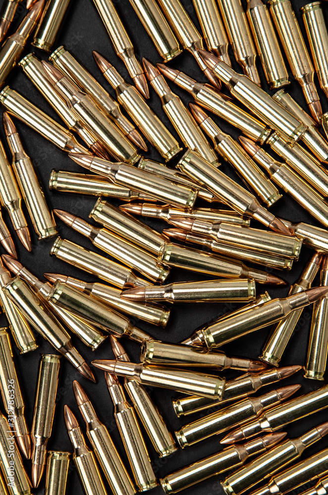 Cartridges for weapons on a dark background. Shiny brass ammo on black ...