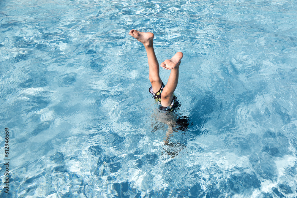 A boy does a handstand in the swimming pool Stock Photo | Adobe Stock