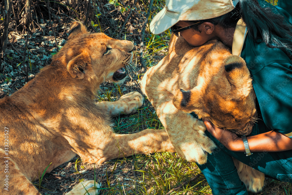 African woman crouching on the ground and snuggling, embracing and ...