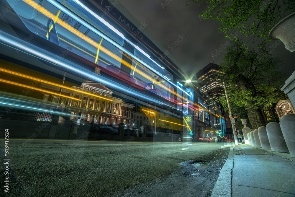 Long exposure city bus lights passing by State House building. Stock ...