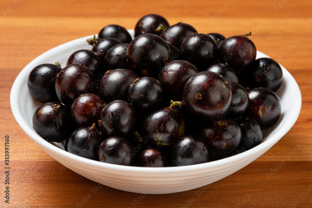 Jabuticaba in the bowl on wooden table. Jaboticaba or Jabuticaba is the ...