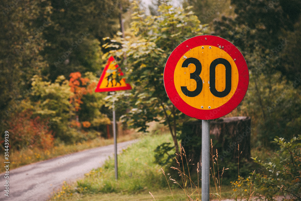 Yellow and red road traffic signs circular "speed limit 30" and ...