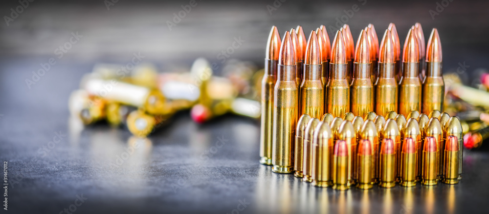 Various kind of bullets or ammonution on dark stone table. Bullet pile ...