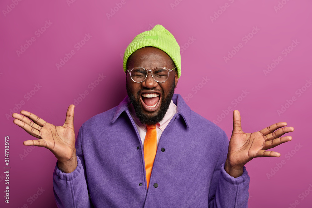 Foto Emotional man with thick bristle, exclaims very loudly, spreads ...