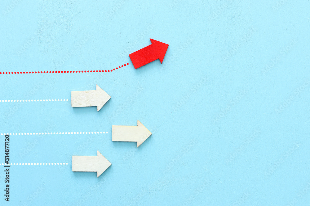 Concept image of red arrow facing opposite direction from other arrows ...