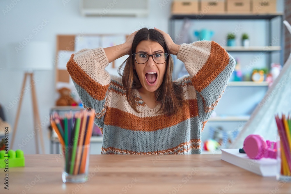 Young beautiful teacher woman wearing sweater and glasses sitting on ...