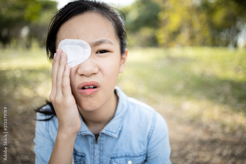 Asian child girl has a blindfolded bandaged eye,female people cover ...