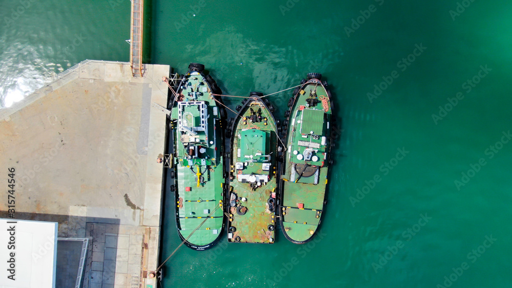 aerial view of three boats tugs alongside to each other, awaiting for ...