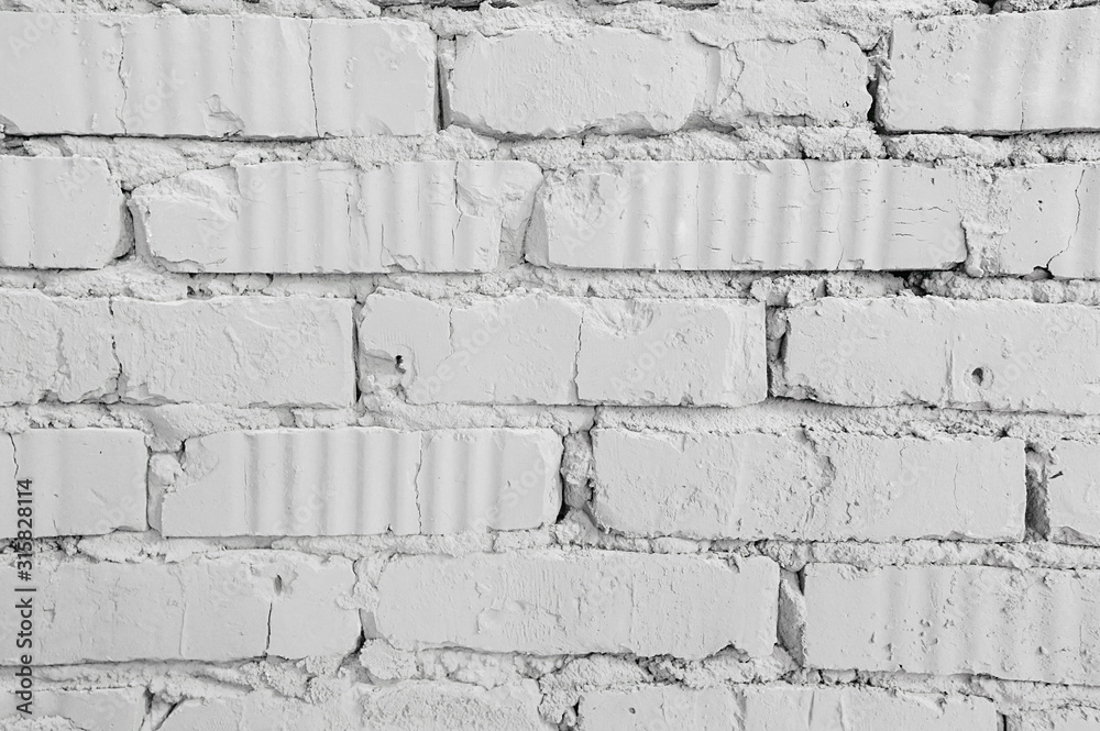 homogeneous background clean white brick wall with cracks from old age ...